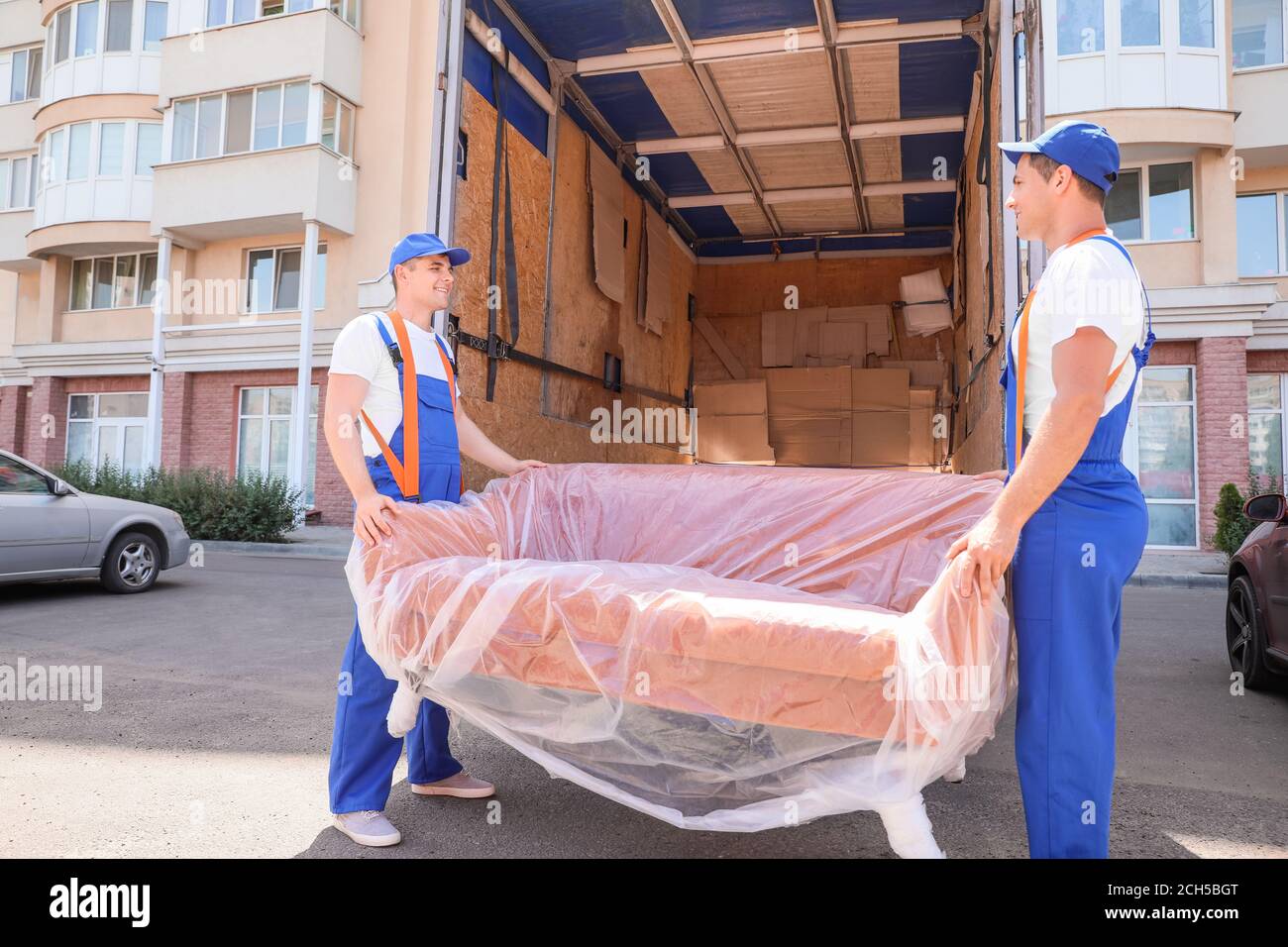 Loaders taking furniture from truck Stock Photo - Alamy