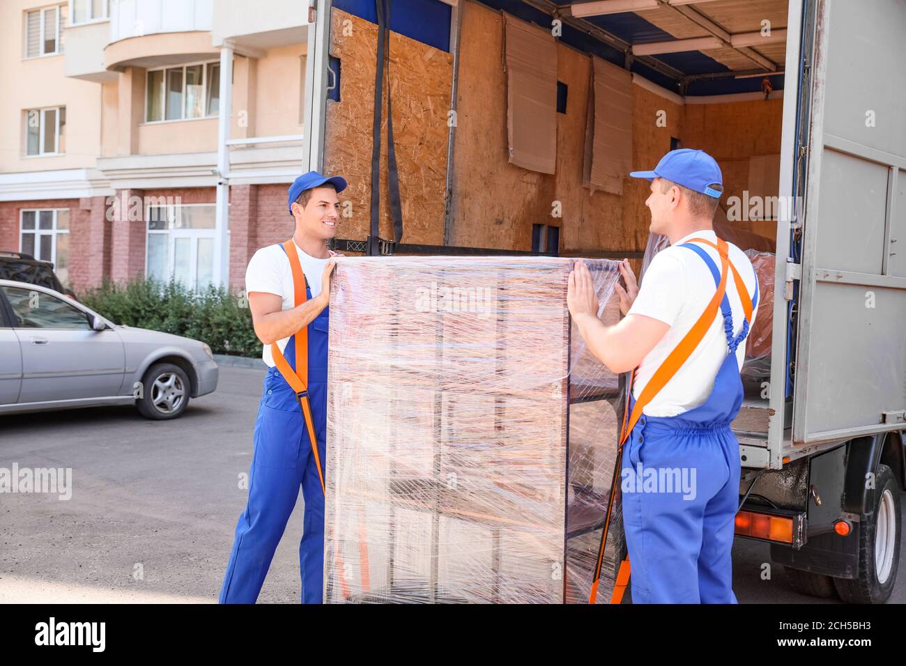 Loaders taking furniture from truck Stock Photo - Alamy