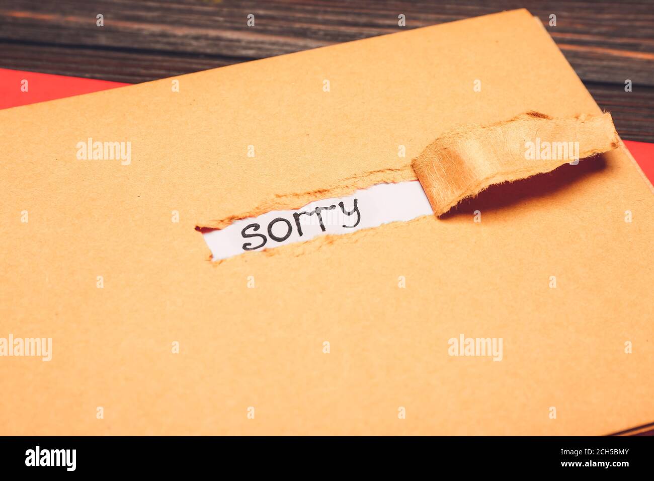 Word SORRY visible through torn paper page, closeup Stock Photo - Alamy