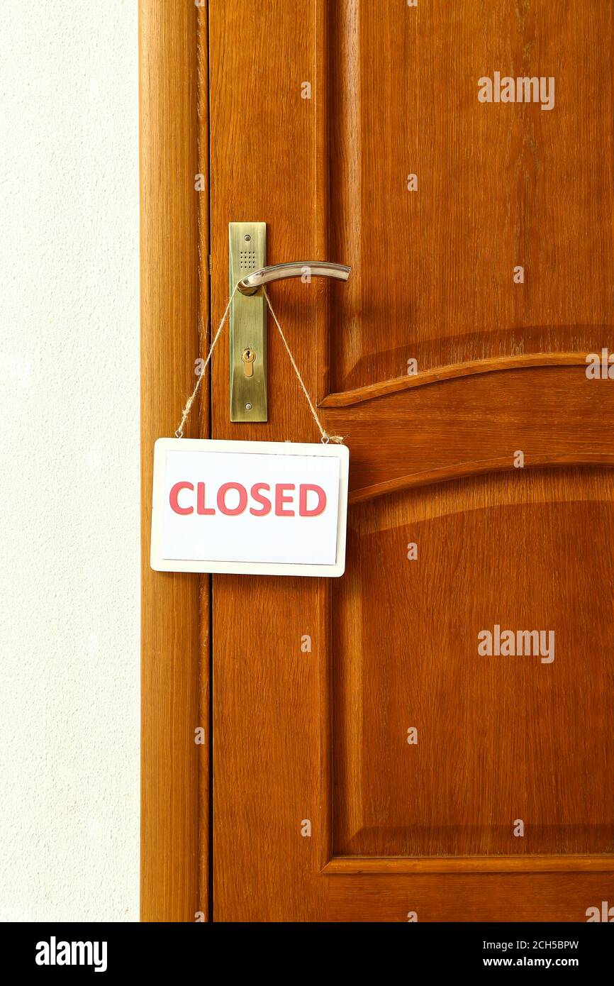 Board with word CLOSED hanging on door indoors Stock Photo - Alamy