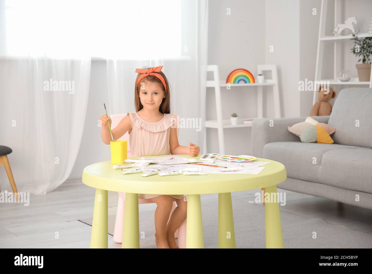 Cute little girl coloring pictures at home Stock Photo - Alamy