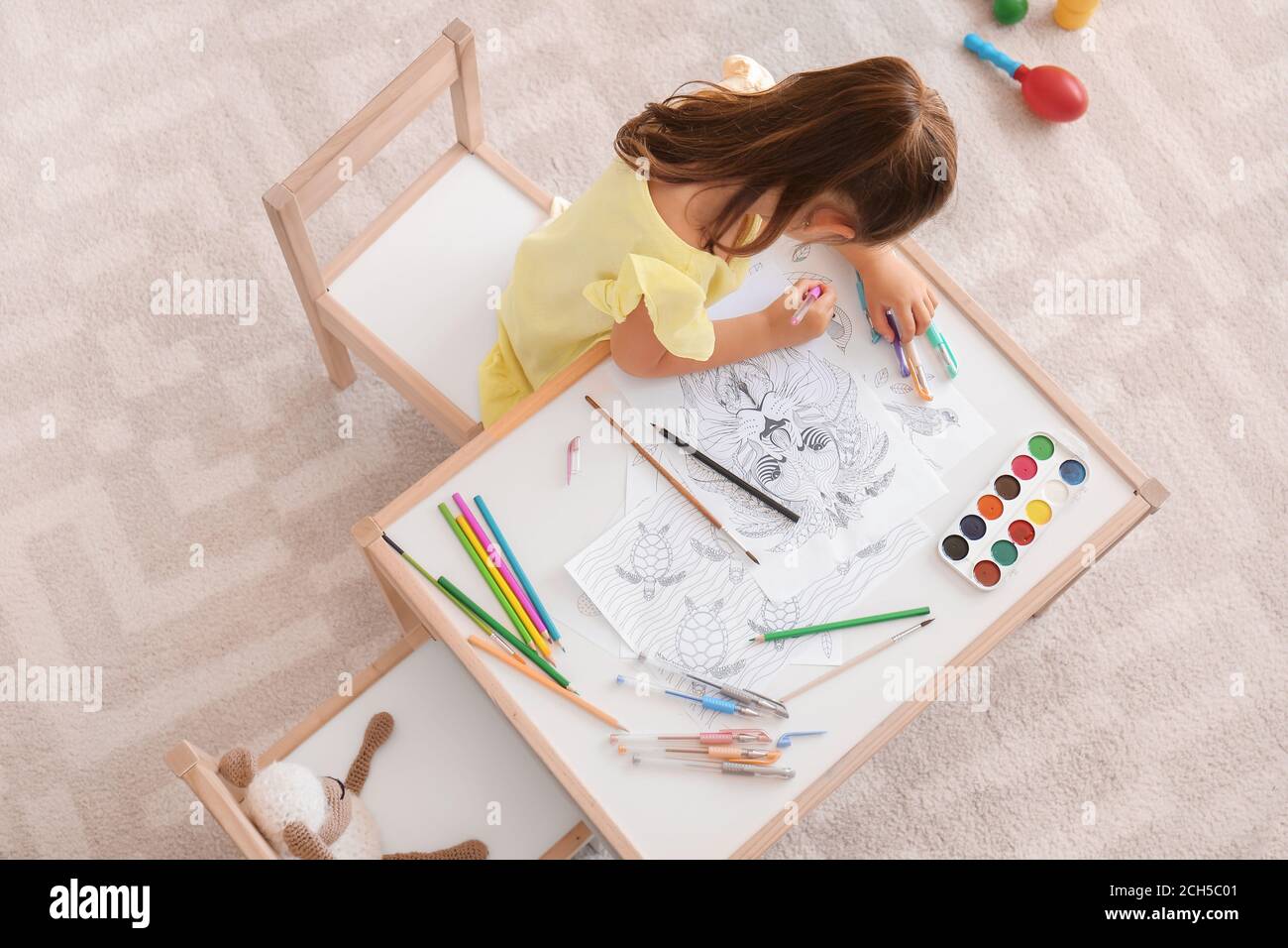 Cute little girl coloring pictures at home Stock Photo - Alamy