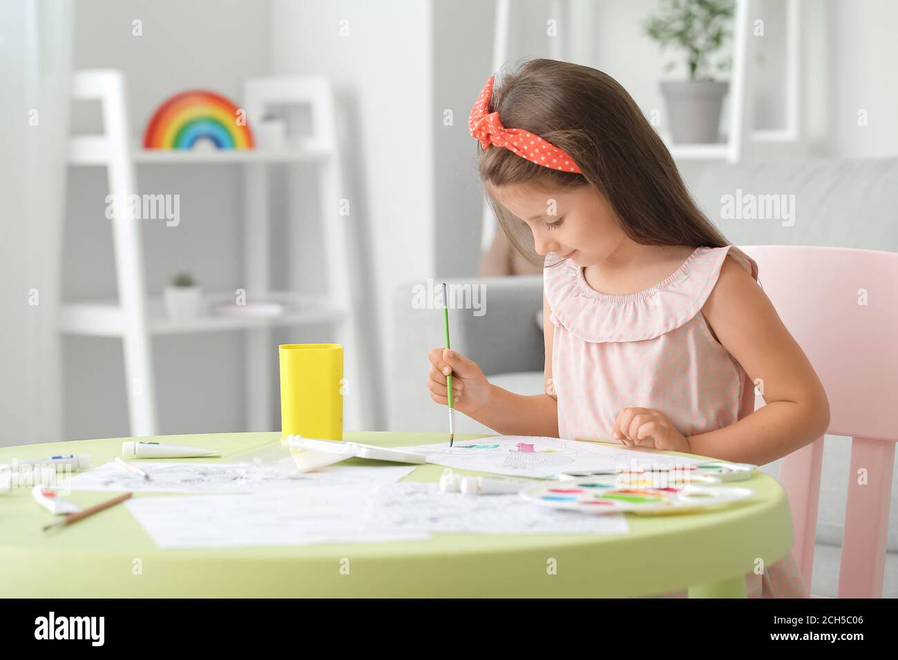 Cute little girl coloring pictures at home Stock Photo - Alamy