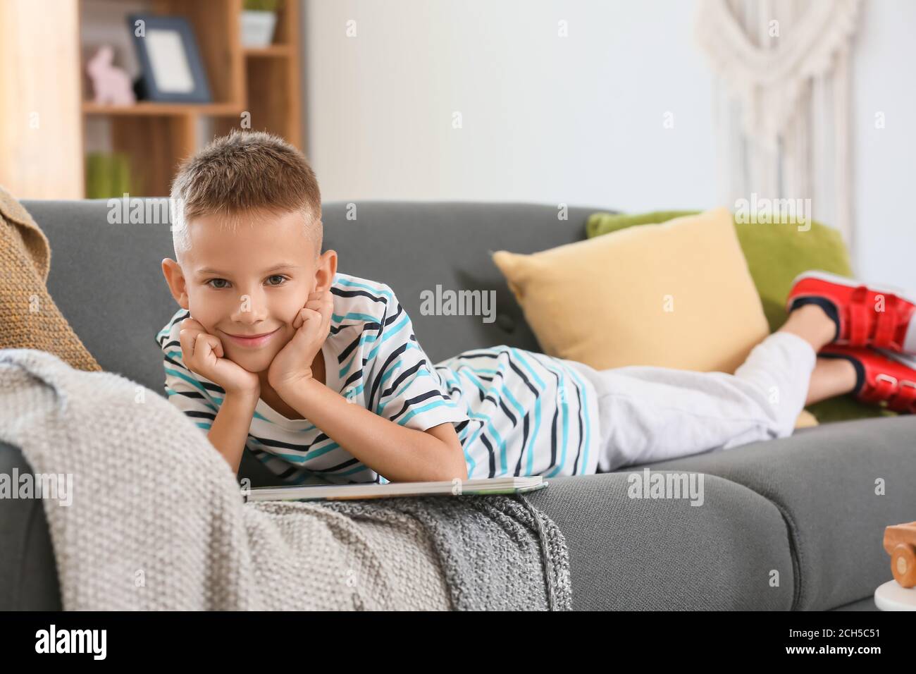 Cute little boy reading book at home Stock Photo - Alamy
