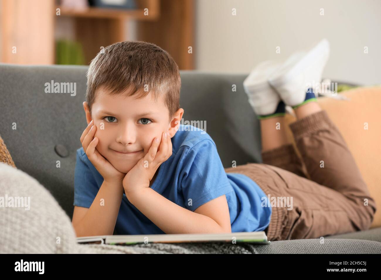 Cute little boy reading book at home Stock Photo - Alamy