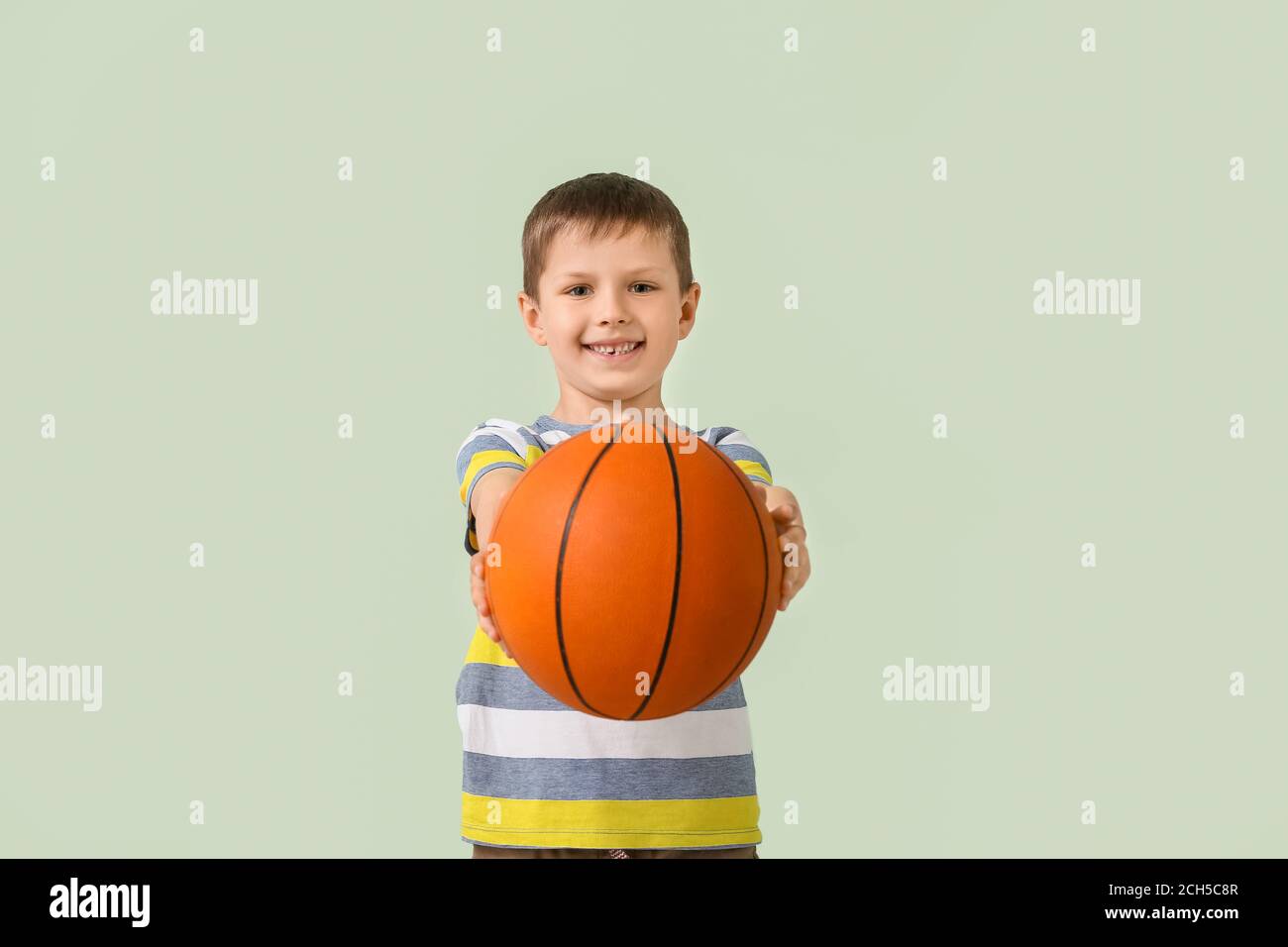 Cute little boy with ball on color background Stock Photo - Alamy