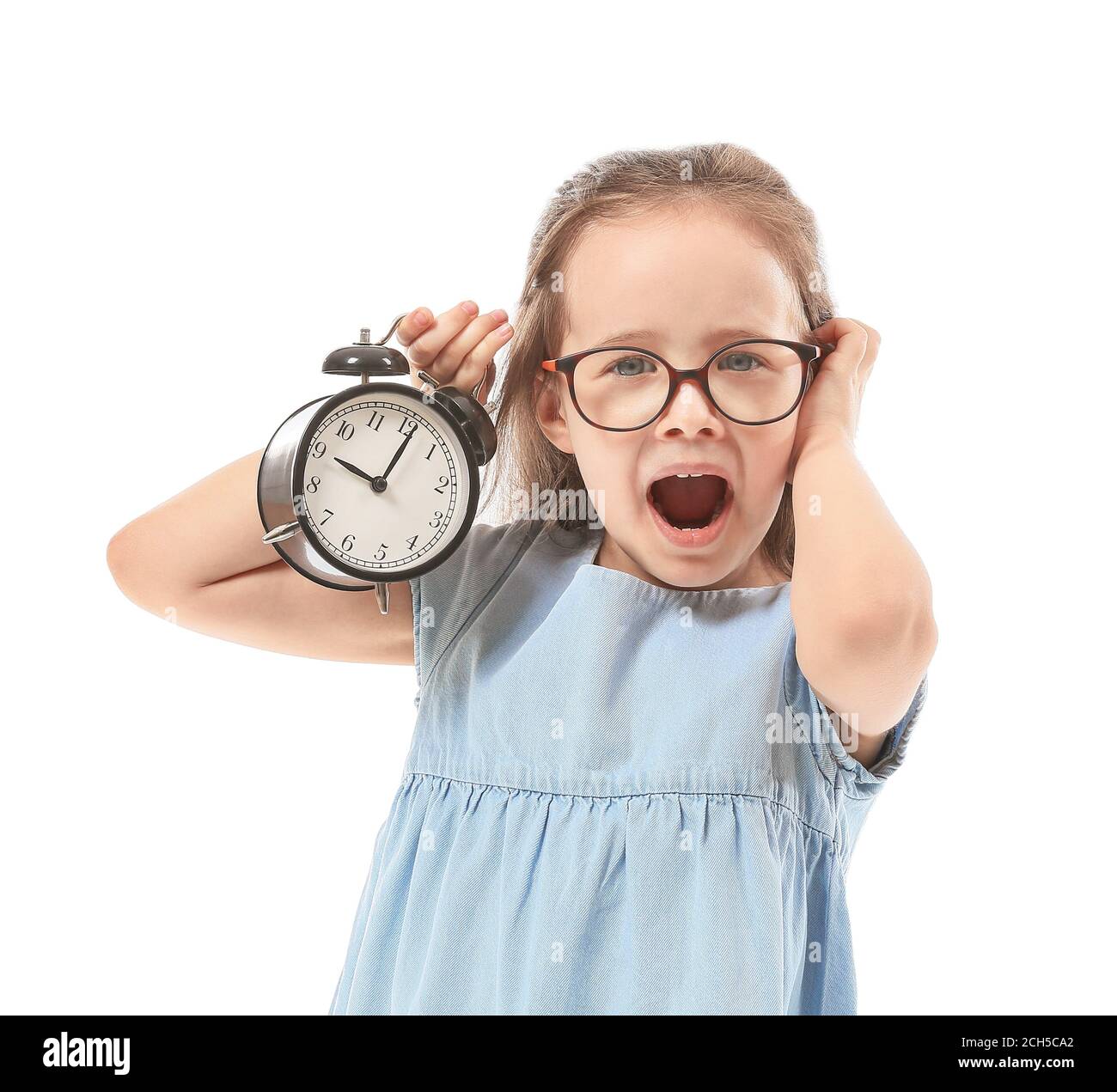 Stressed little girl with alarm clock on white background Stock Photo ...