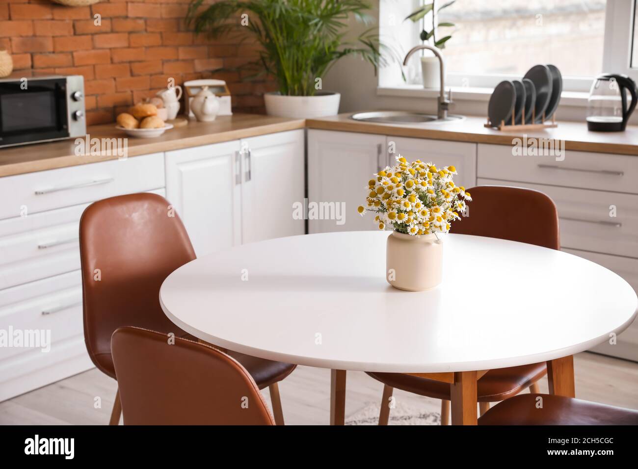 Dining table in interior of modern kitchen Stock Photo - Alamy