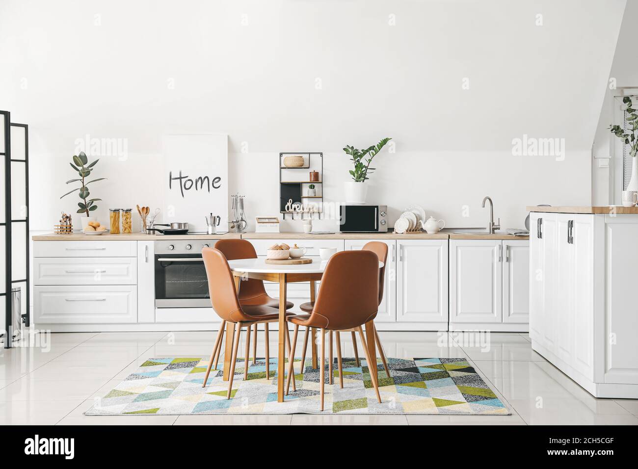 Interior of stylish modern kitchen with dining table Stock Photo - Alamy