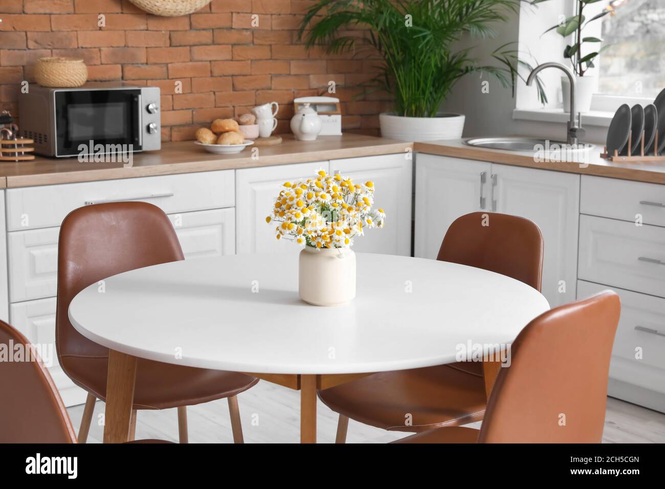 Dining table in interior of modern kitchen Stock Photo - Alamy