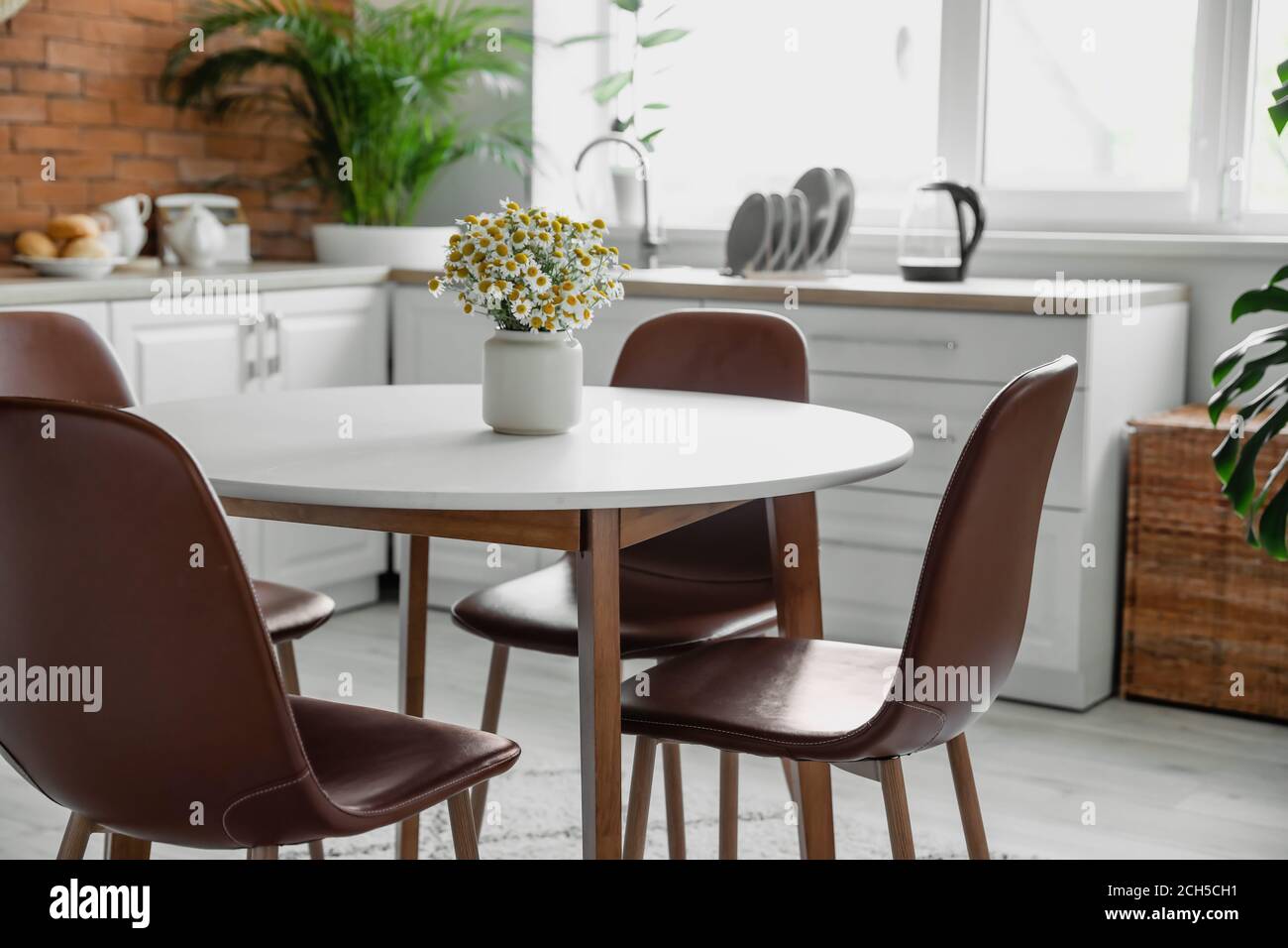 Dining table in interior of modern kitchen Stock Photo - Alamy