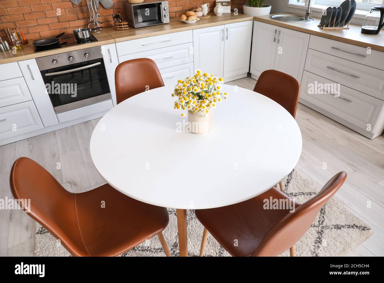Dining table in interior of modern kitchen Stock Photo - Alamy