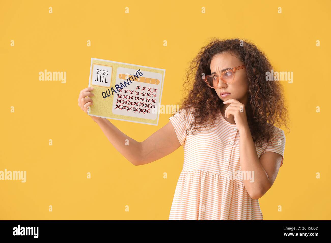 Sad woman holding calendar with written word QUARANTINE against color ...