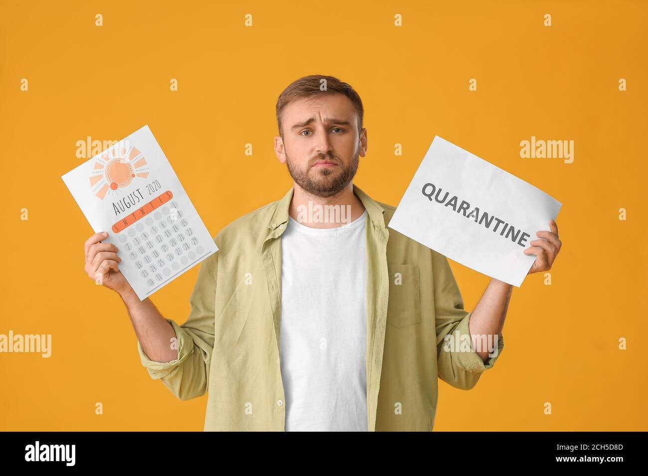 Sad man holding calendar and paper with written word QUARANTINE against ...