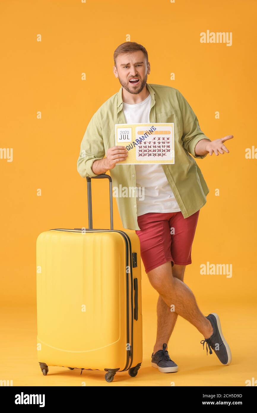 Angry man holding calendar with written word QUARANTINE against color ...