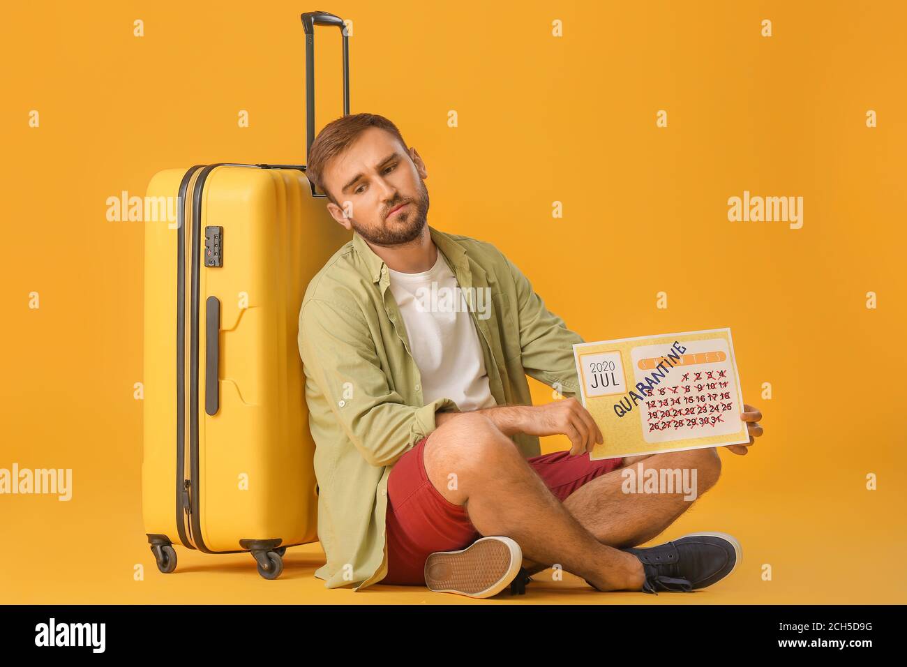 Sad man holding calendar with written word QUARANTINE against color ...