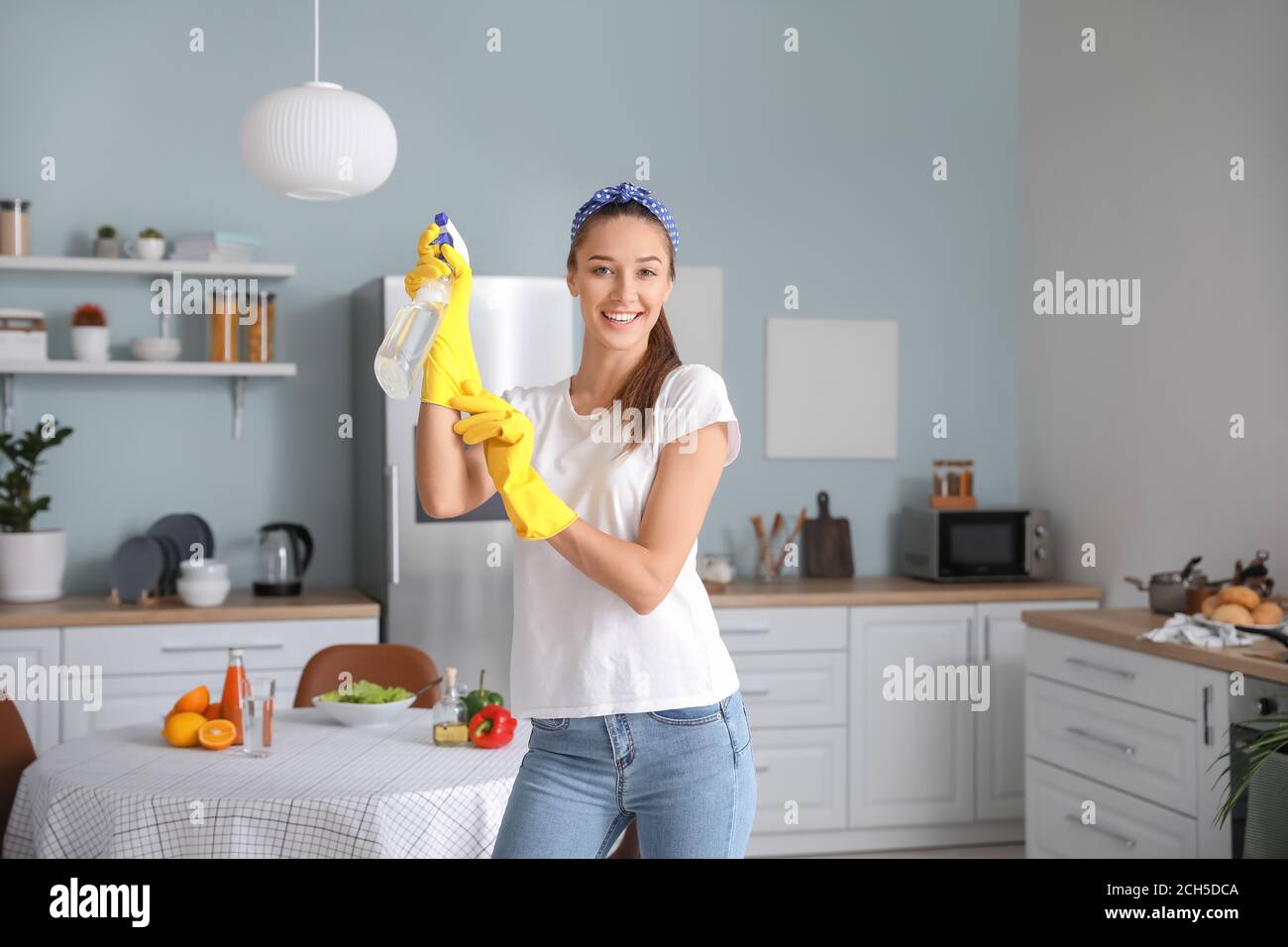 Beautiful young woman cleaning kitchen Stock Photo - Alamy