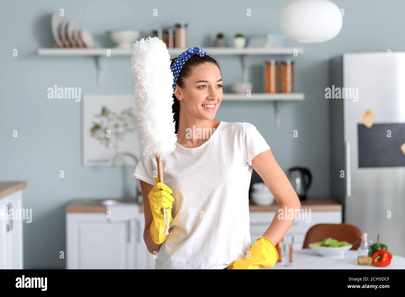 Beautiful young woman cleaning kitchen Stock Photo - Alamy