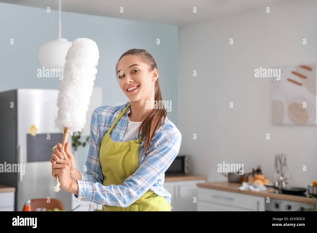 Beautiful young woman cleaning kitchen Stock Photo - Alamy