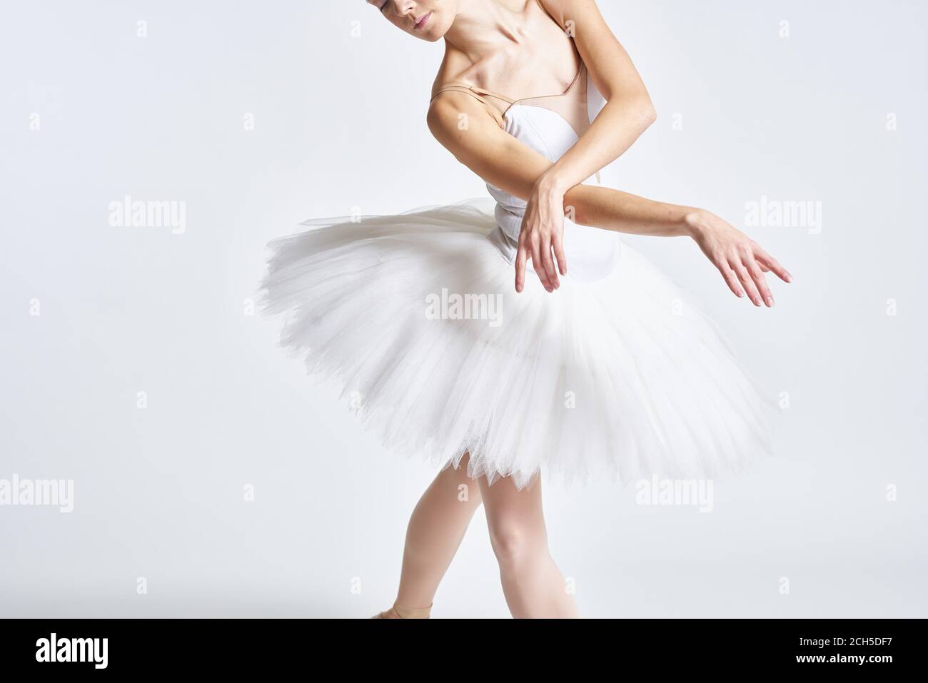 Ballerina in a white tutu dance performed on a light background Stock ...