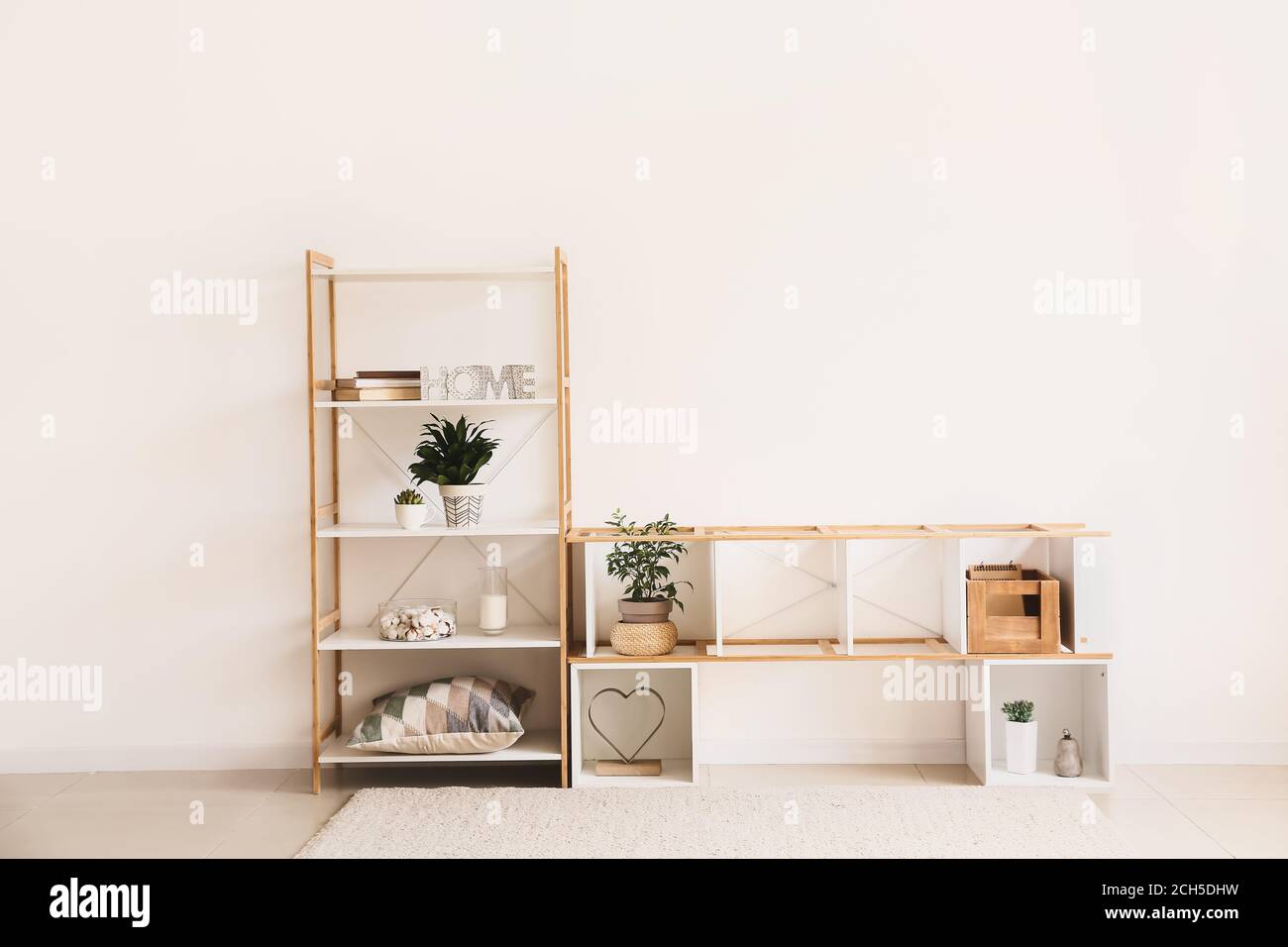 Stylish stand and rack with decor near light wall in room Stock Photo ...