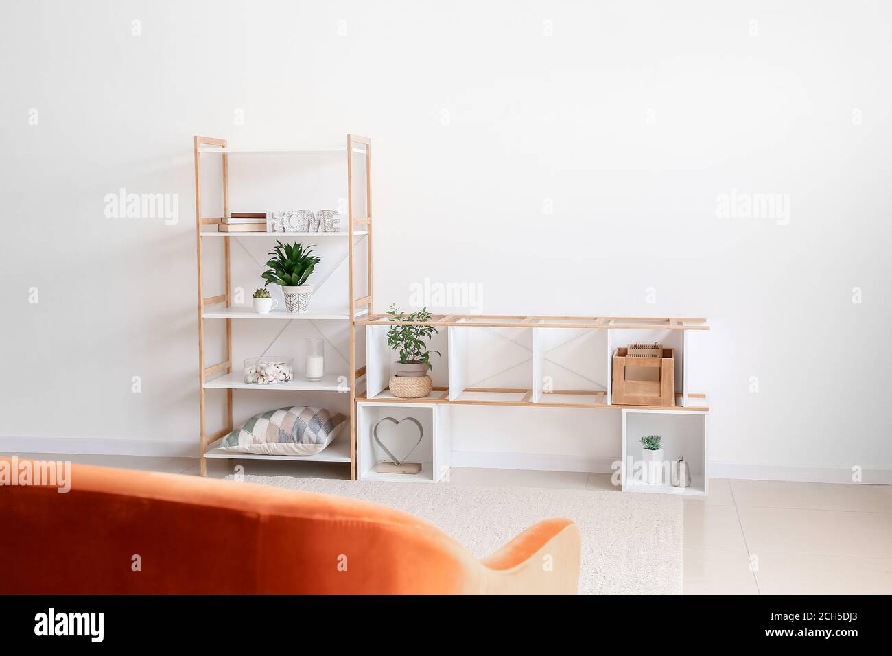 Stylish stand and rack with decor near light wall in room Stock Photo ...