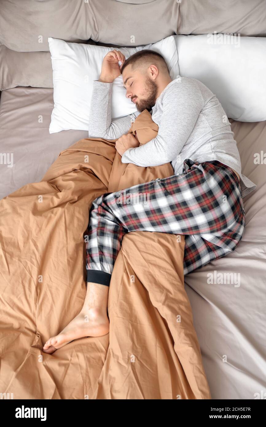 Young man sleeping in bed at home Stock Photo - Alamy