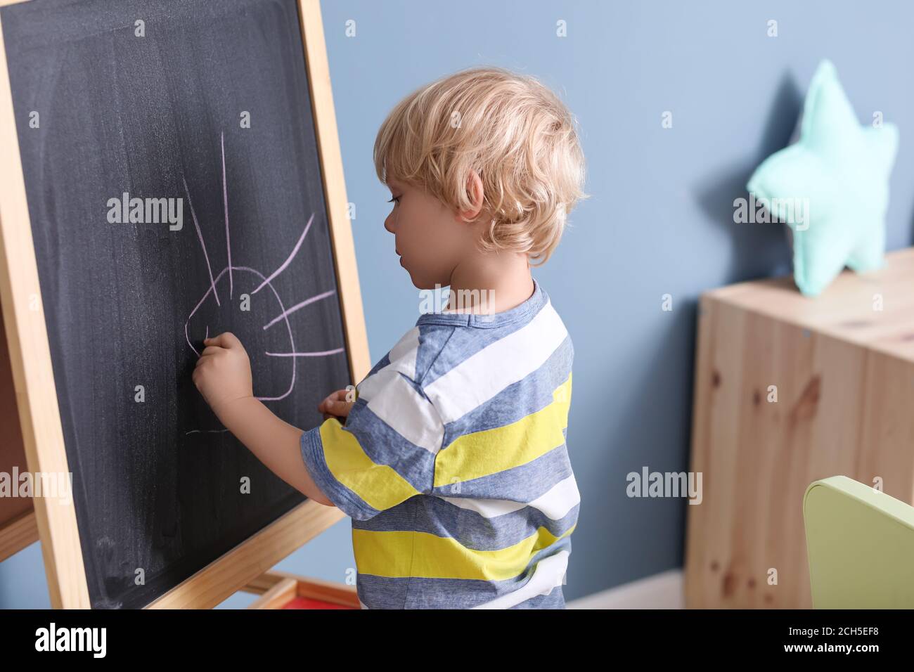 Cute little boy drawing in kindergarten Stock Photo - Alamy