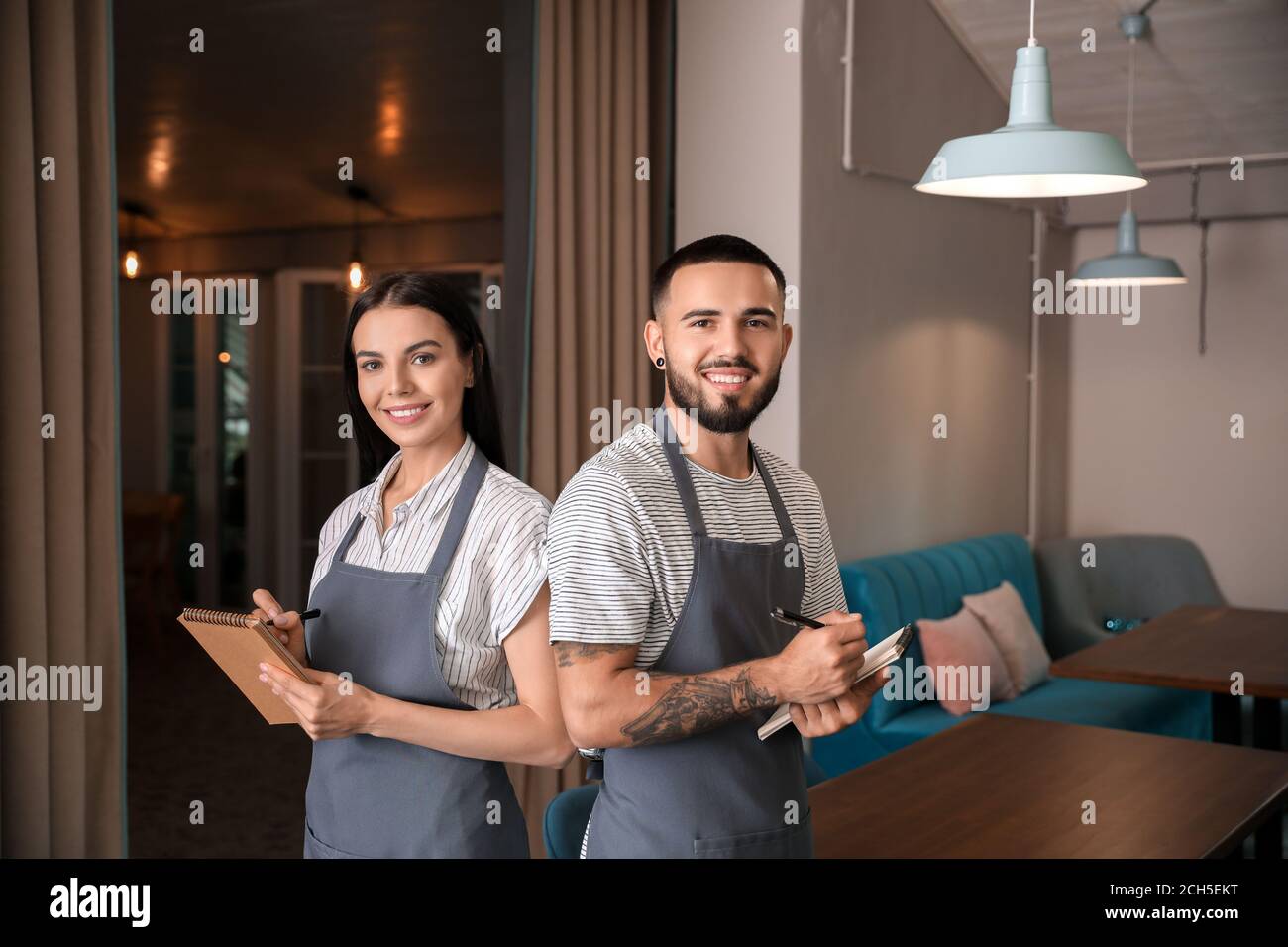 Portrait of young waiters in restaurant Stock Photo - Alamy
