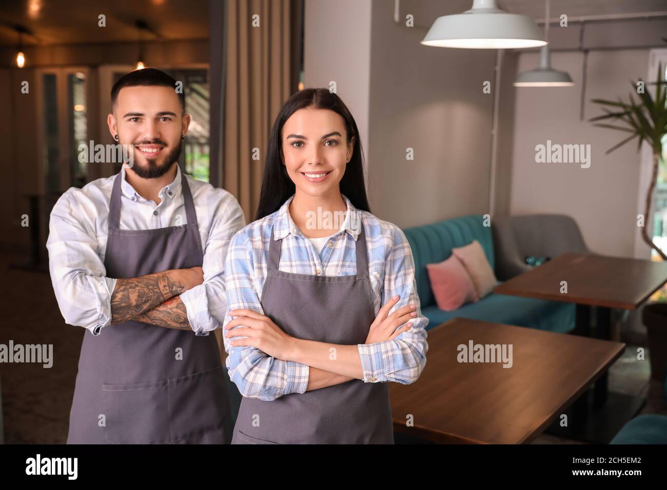 Portrait of young waiters in restaurant Stock Photo - Alamy