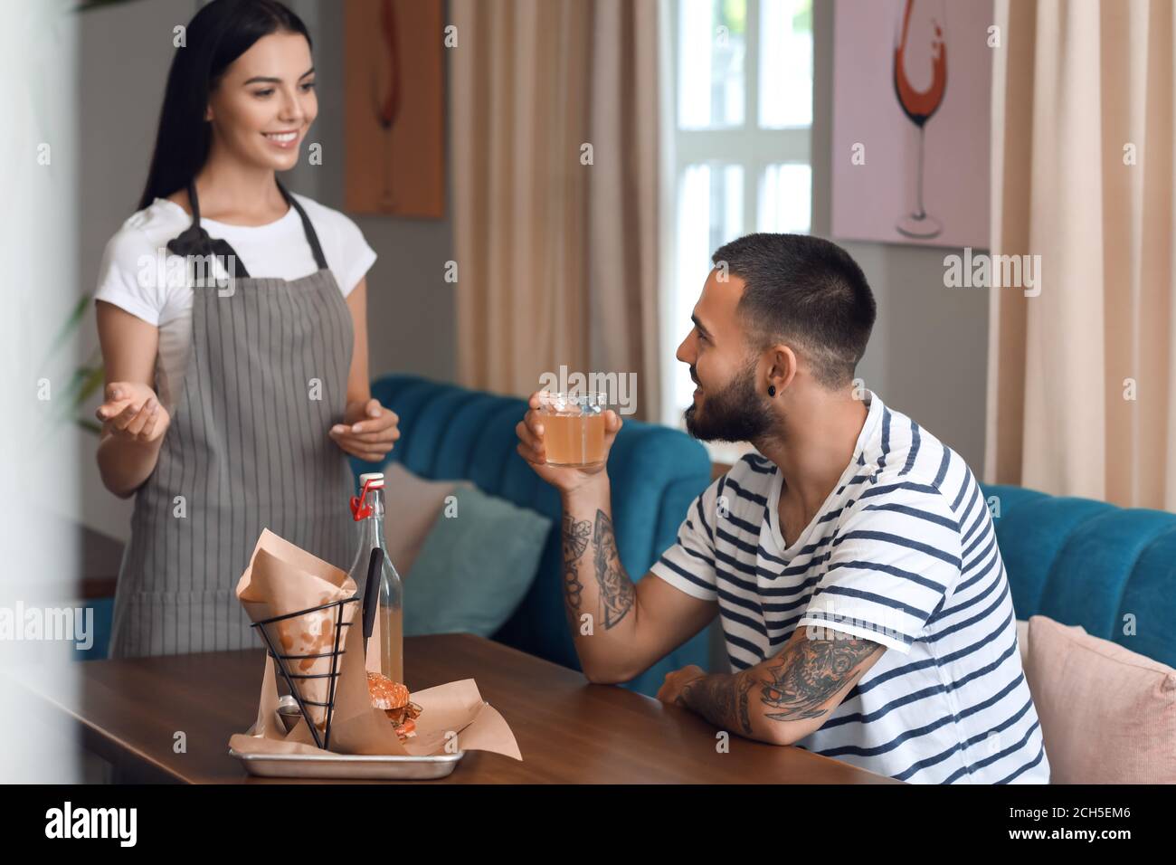 Waitress serving client in restaurant Stock Photo - Alamy