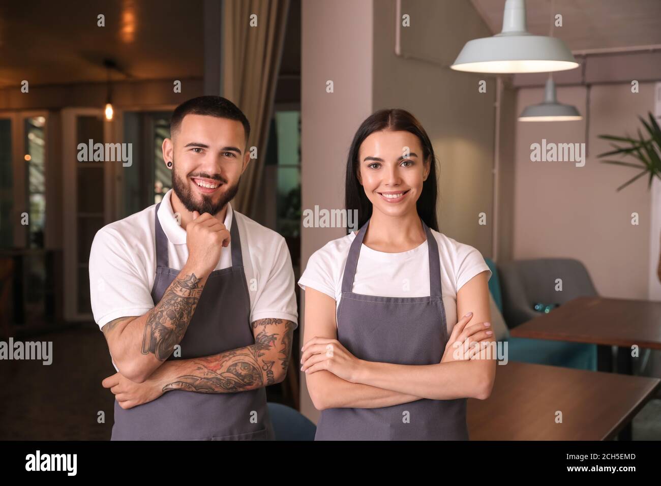 Portrait of young waiters in restaurant Stock Photo - Alamy