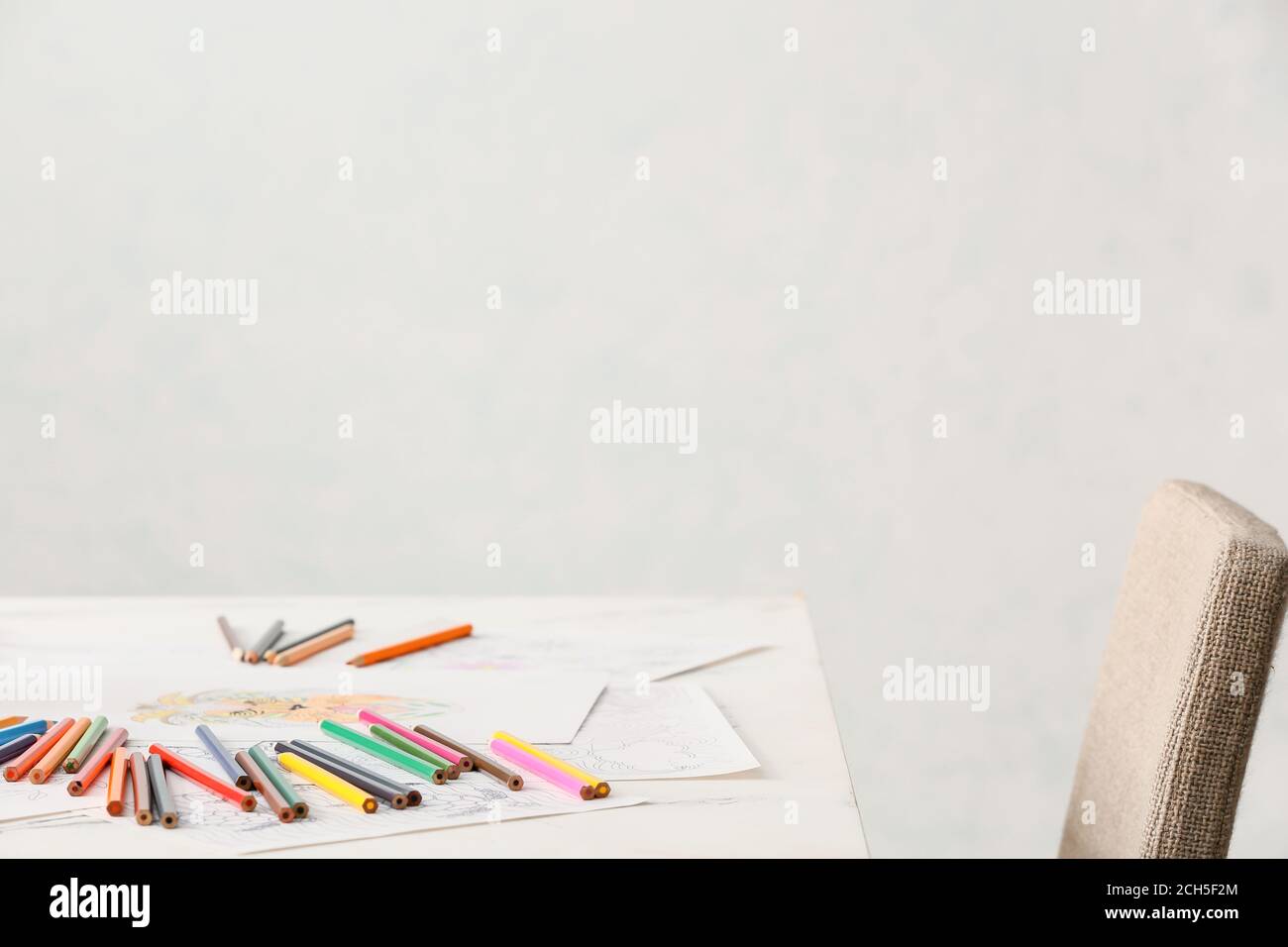 Coloring pictures and pencils on table Stock Photo - Alamy