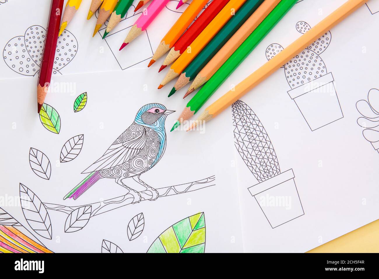 Coloring pictures and pencils on table Stock Photo - Alamy