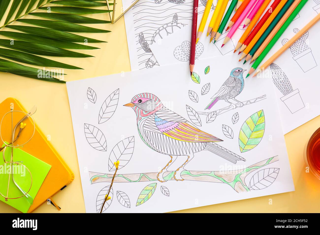 Coloring pictures and pencils on table Stock Photo - Alamy