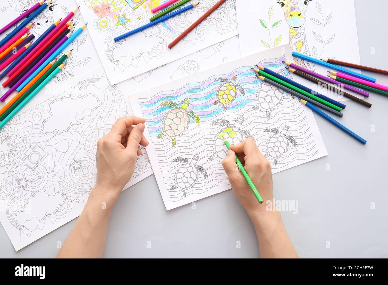 Woman coloring picture at table Stock Photo - Alamy