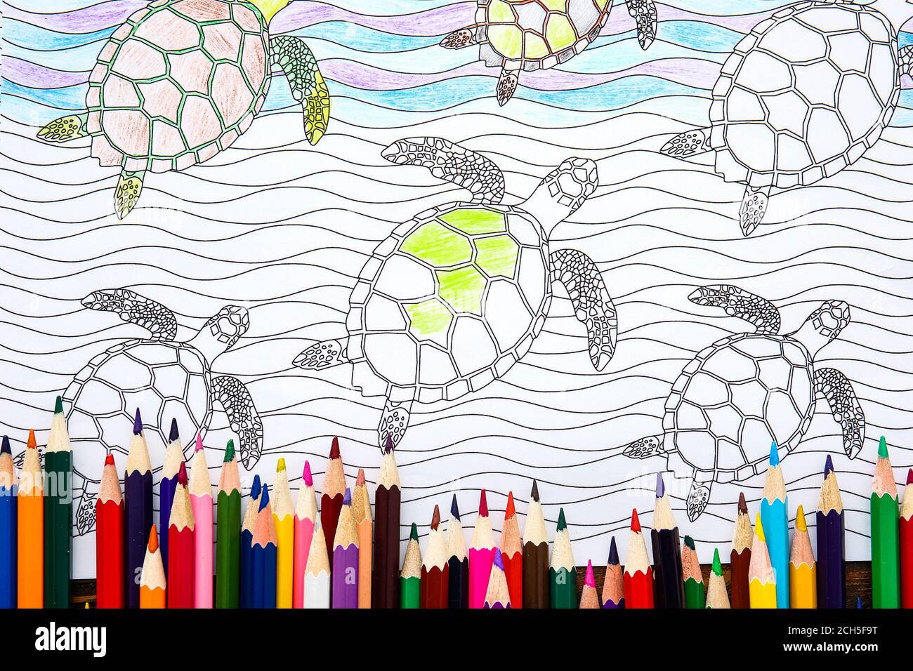 Coloring picture and pencils on table Stock Photo - Alamy