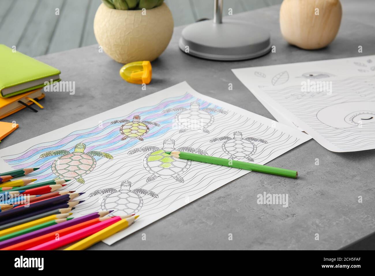 Coloring pictures and pencils on table Stock Photo - Alamy