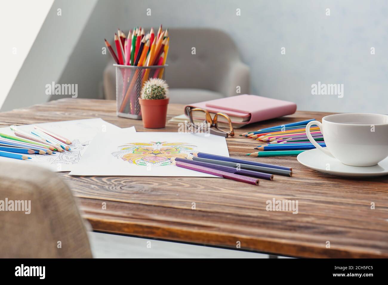 Coloring pictures and pencils on table Stock Photo - Alamy
