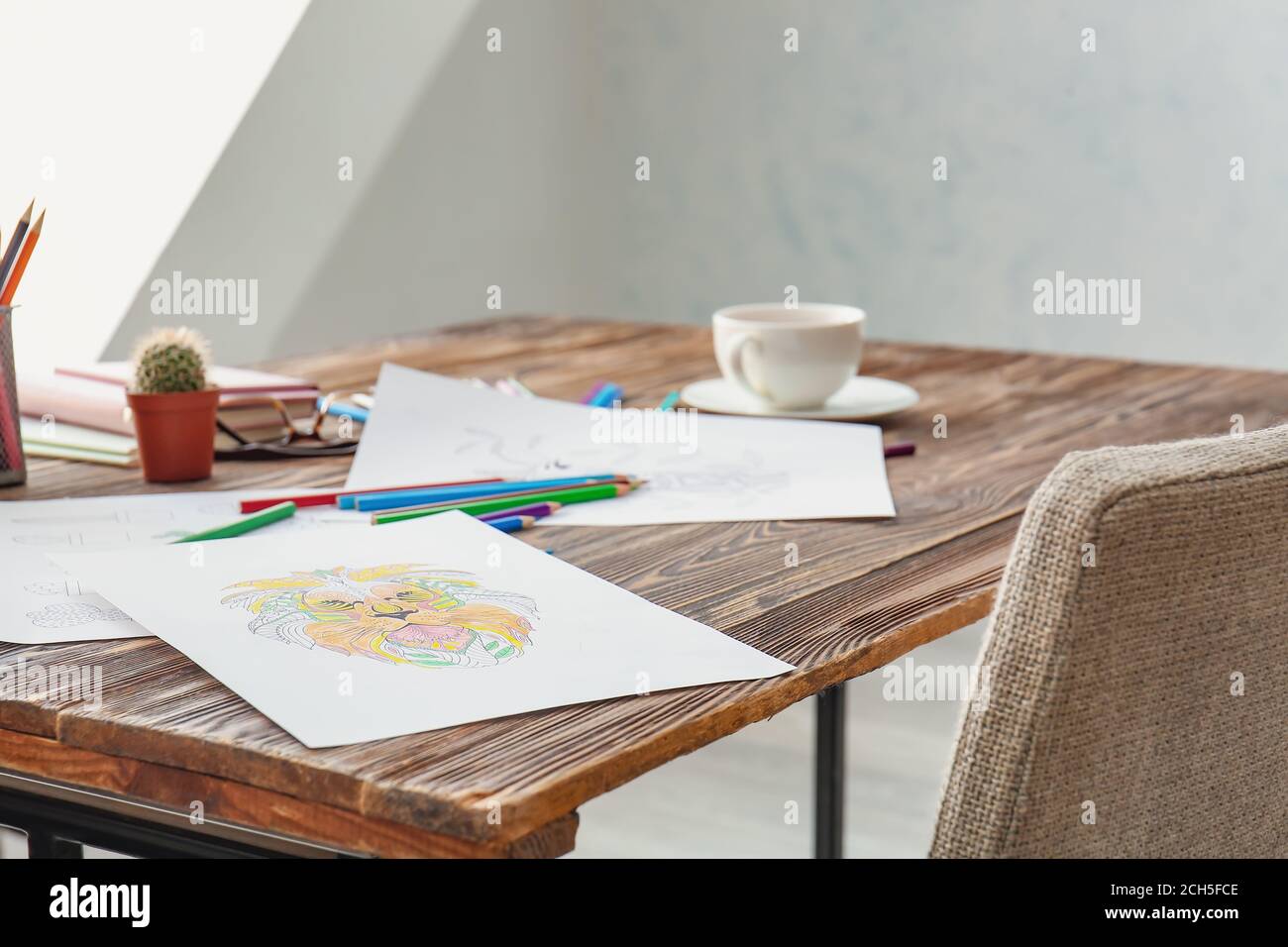 Coloring pictures and pencils on table Stock Photo - Alamy