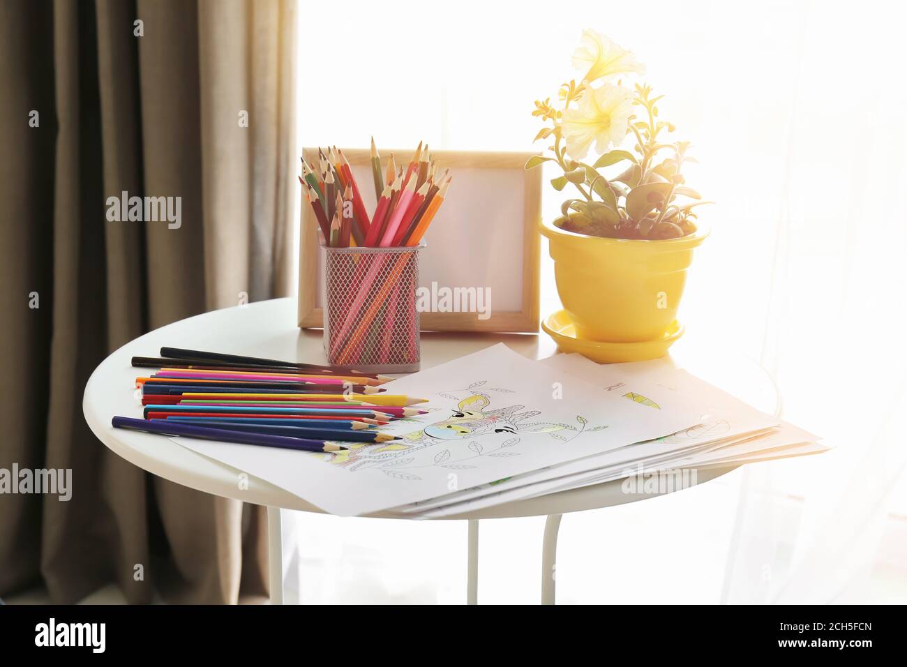 Coloring pictures and pencils on table Stock Photo - Alamy