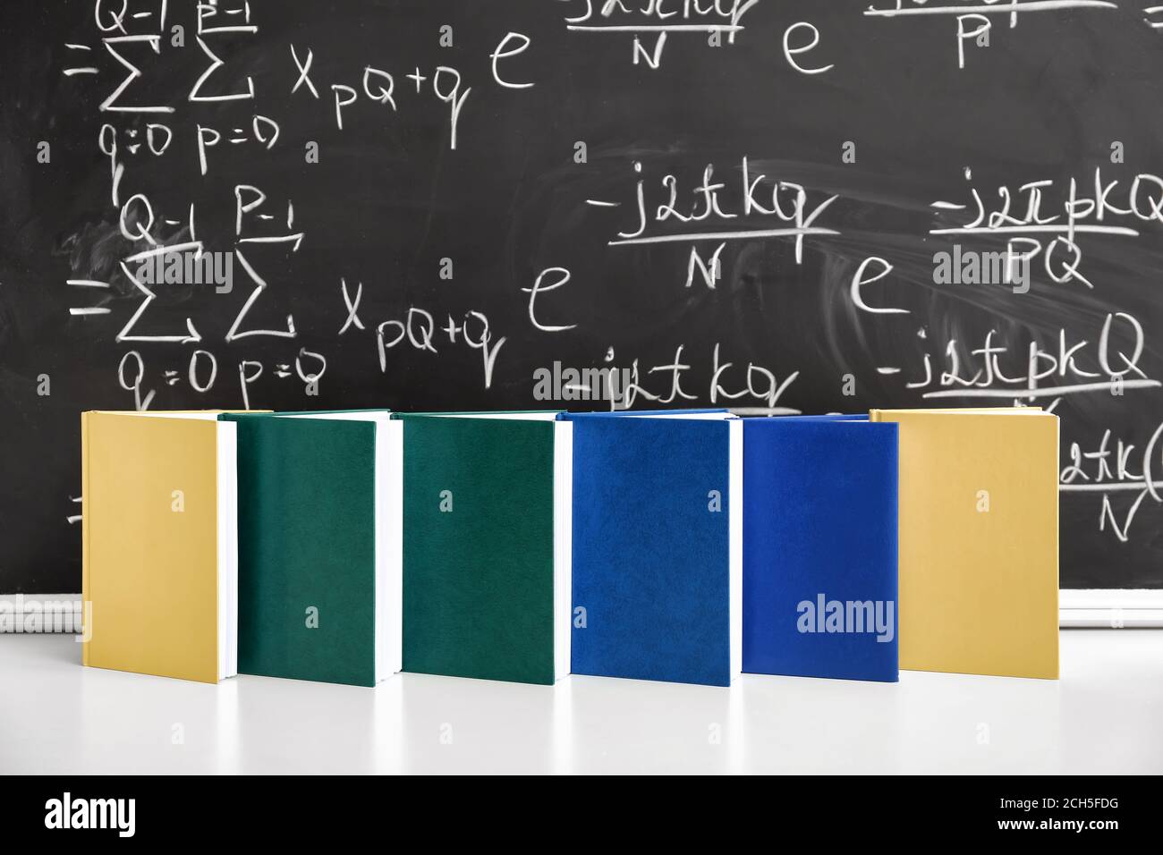 Books on table in classroom Stock Photo - Alamy