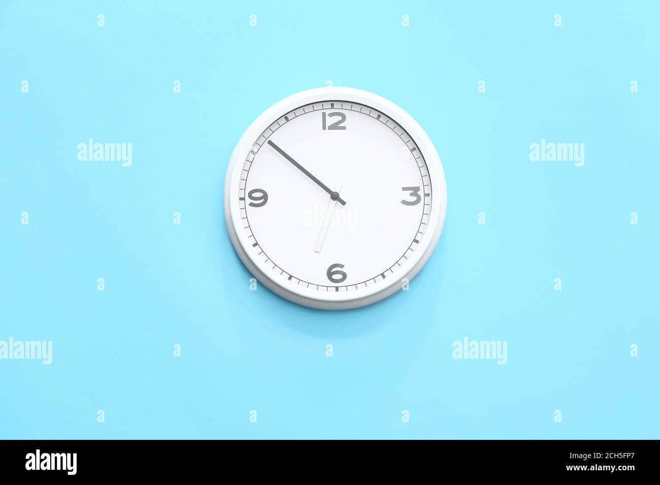Simple clock on color background Stock Photo - Alamy