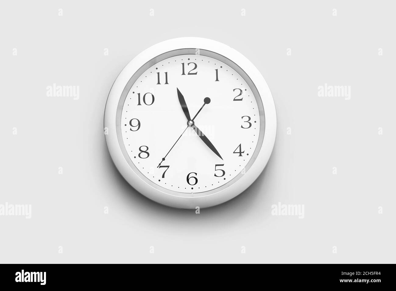 Simple clock on light background Stock Photo - Alamy