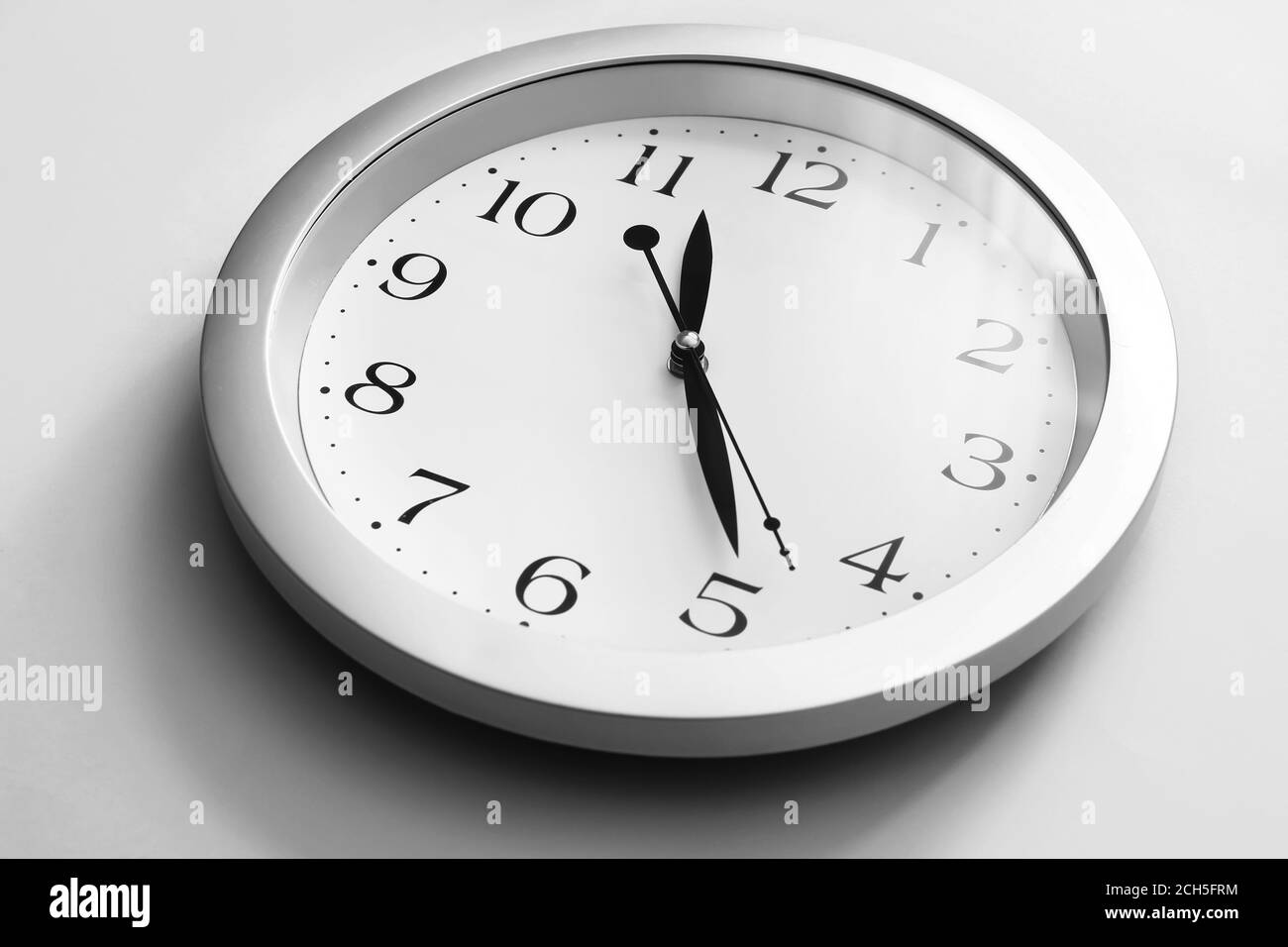 Simple clock on light background Stock Photo - Alamy