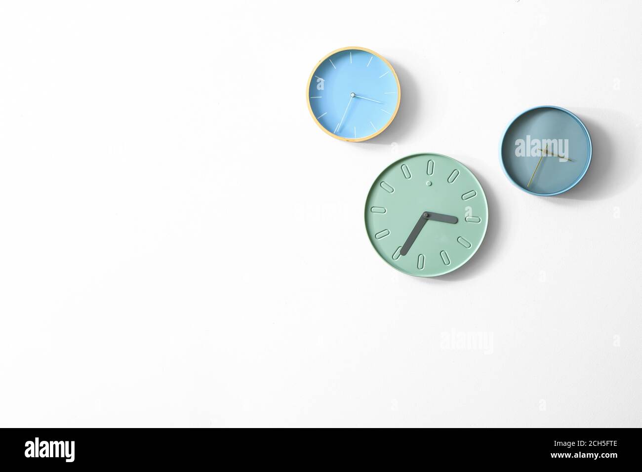 Simple clocks on light wall Stock Photo - Alamy