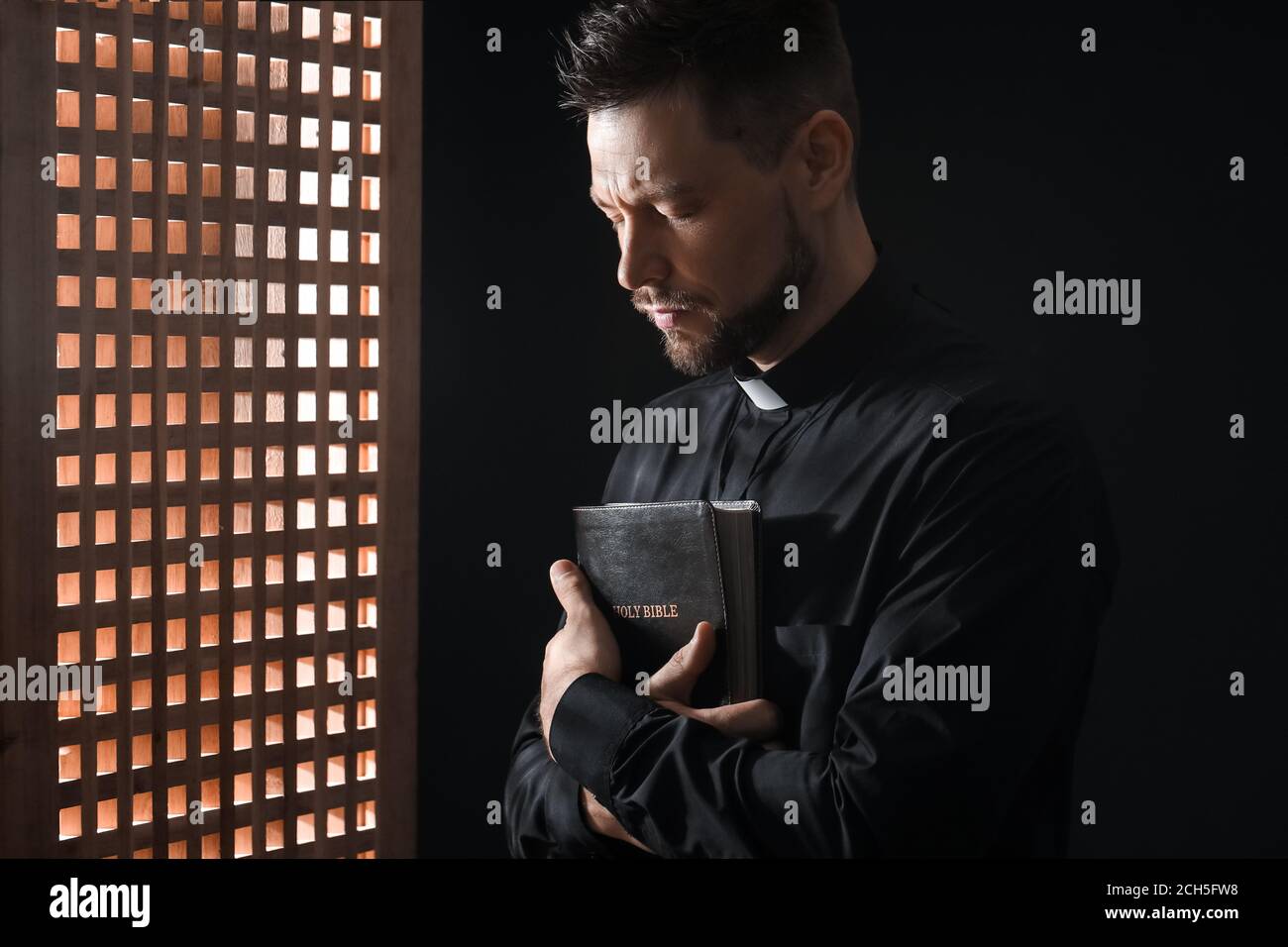 Male priest in confession booth Stock Photo - Alamy
