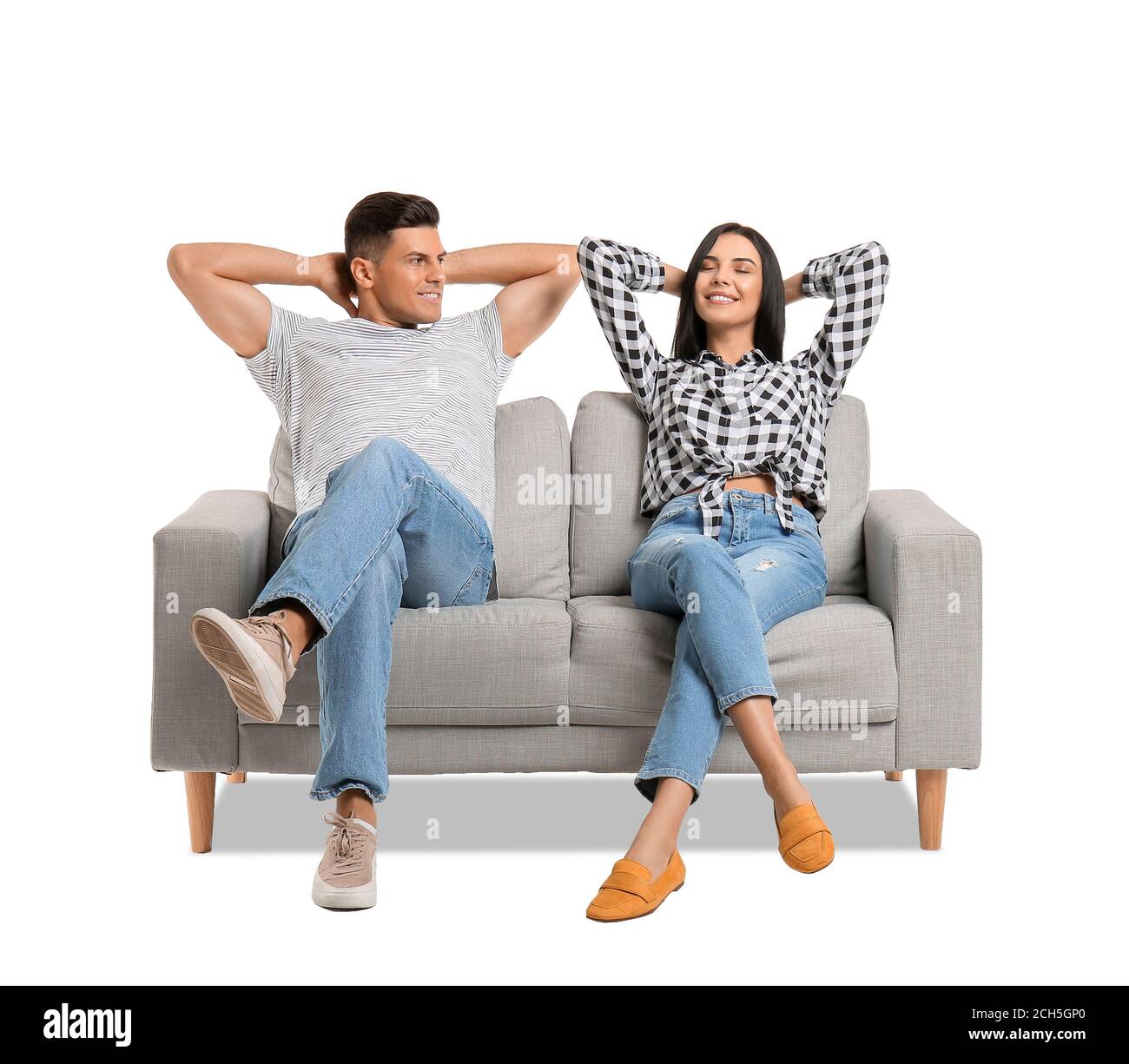 Young couple relaxing on sofa against white background Stock Photo - Alamy