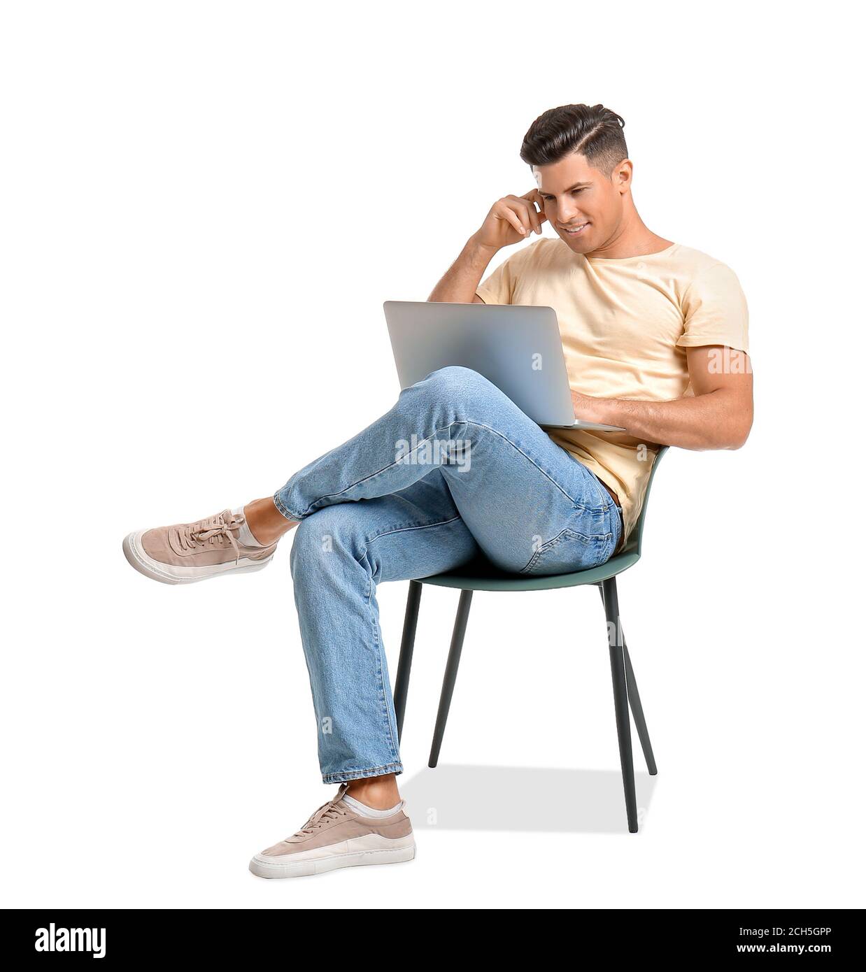 Young man with laptop relaxing on chair against white background Stock ...