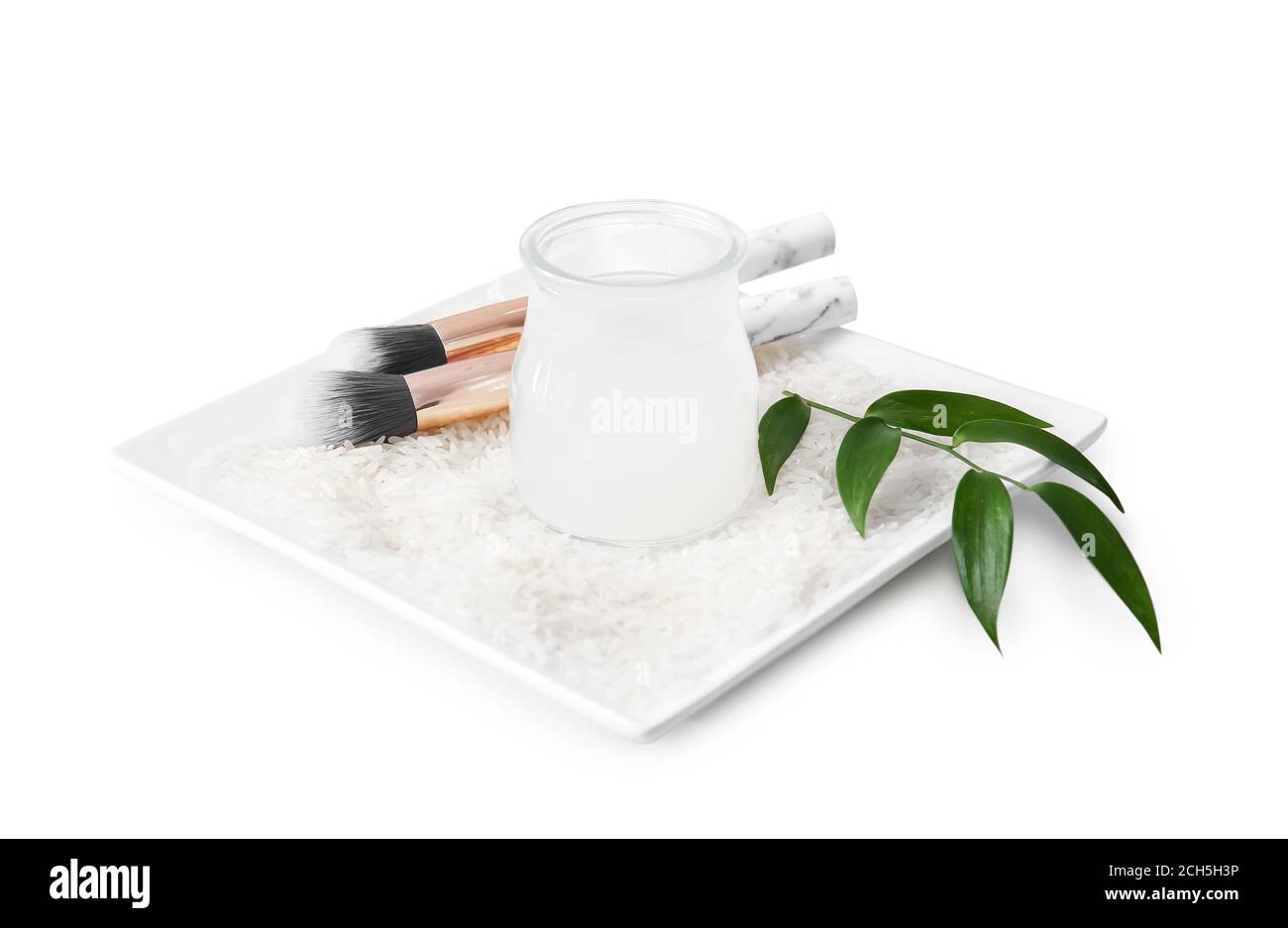 Jar of rice water with brushes on white background Stock Photo - Alamy